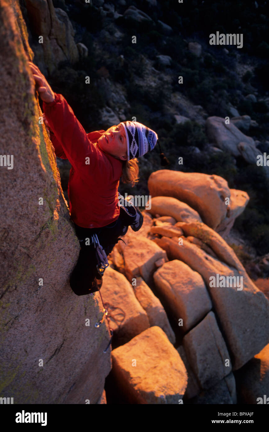 Woman rock climber reachies for small hold on granite arete, Cochise ...