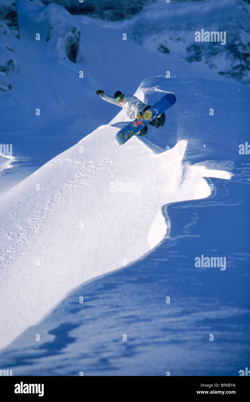 Snowboarder jumping off cornice Stock Photo - Alamy