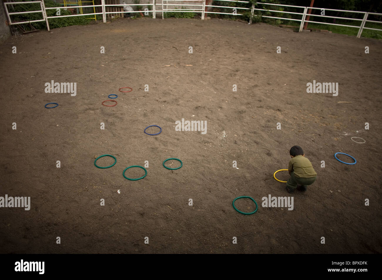 A boy picks hoops up from the ring during a horse therapy session in ...