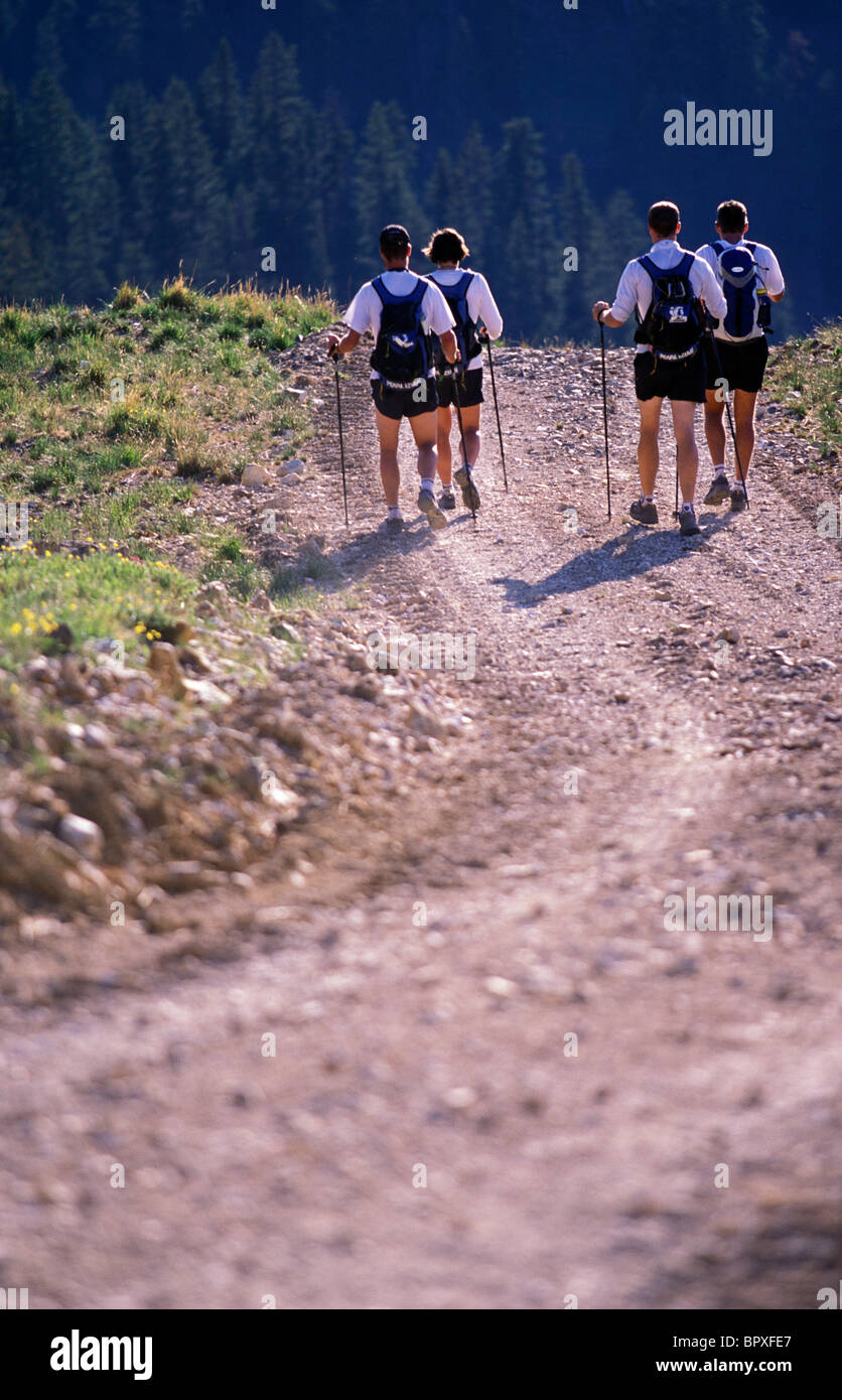 Group of four adults, members of an adventure racing team, hike down a ...