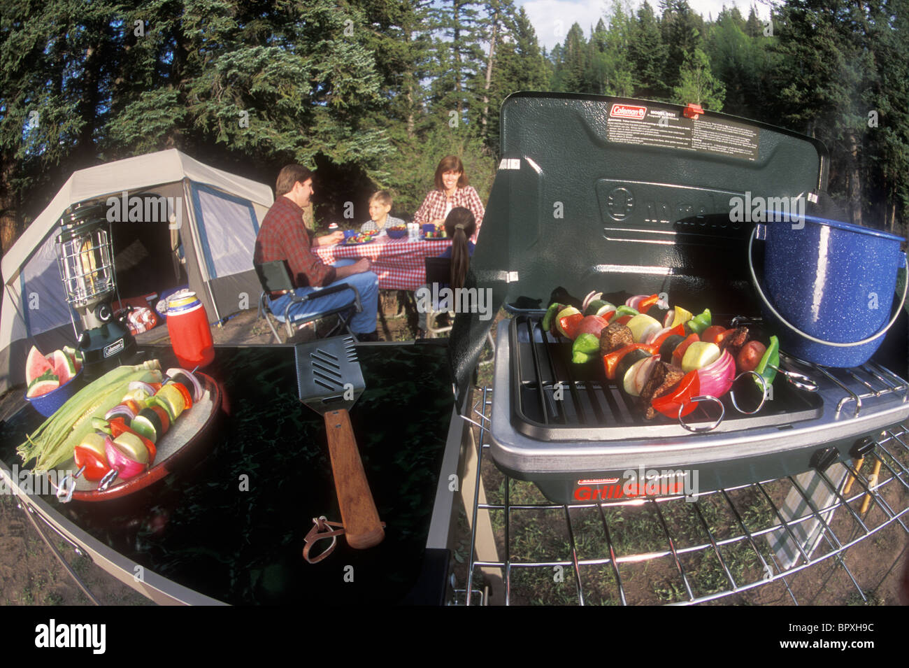 Family enjoying a camp dinner together Stock Photo - Alamy