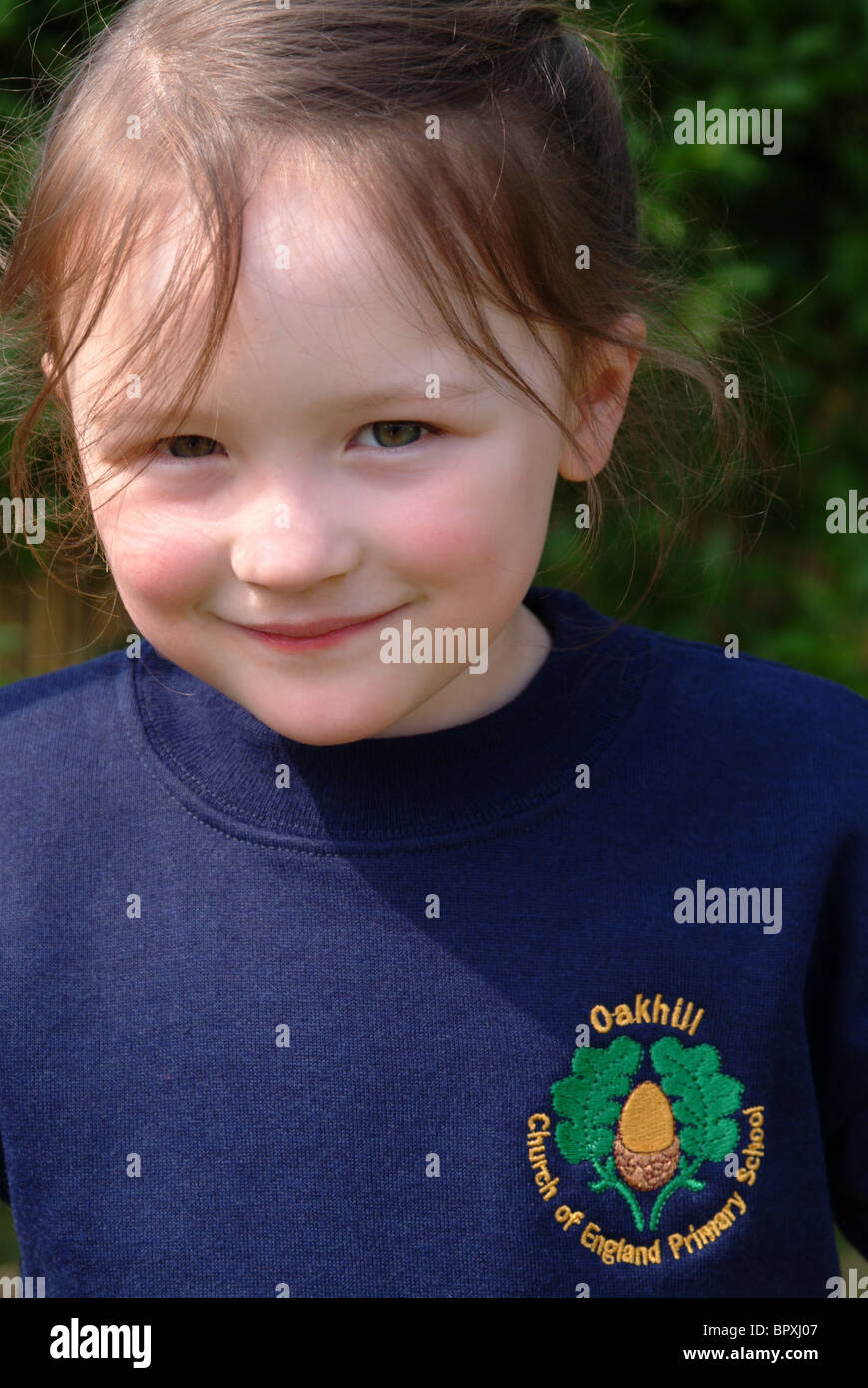Portrait of a little girl wearing school uniform on her first day at ...