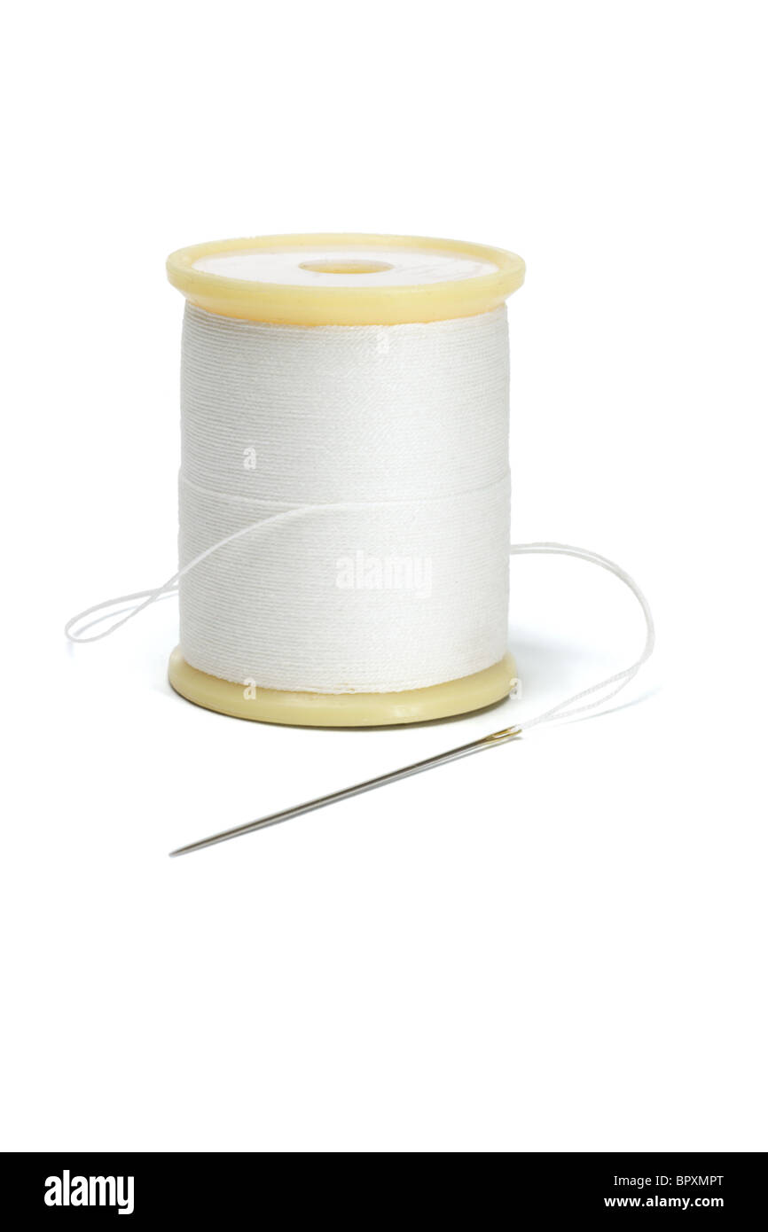 Needle and spool of thread on white background Stock Photo - Alamy