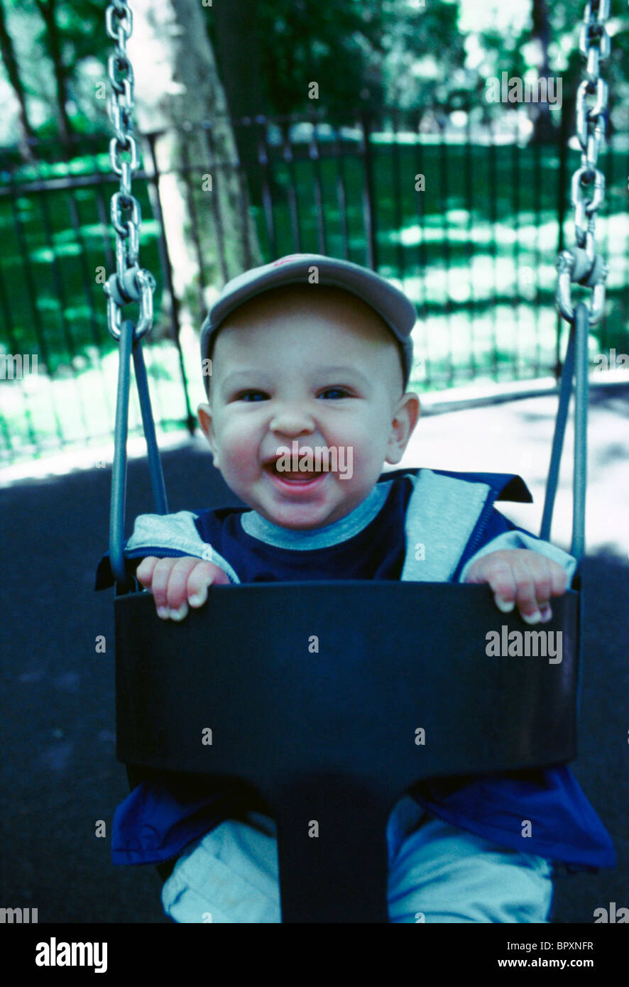 boy playing on swing in park Stock Photo - Alamy