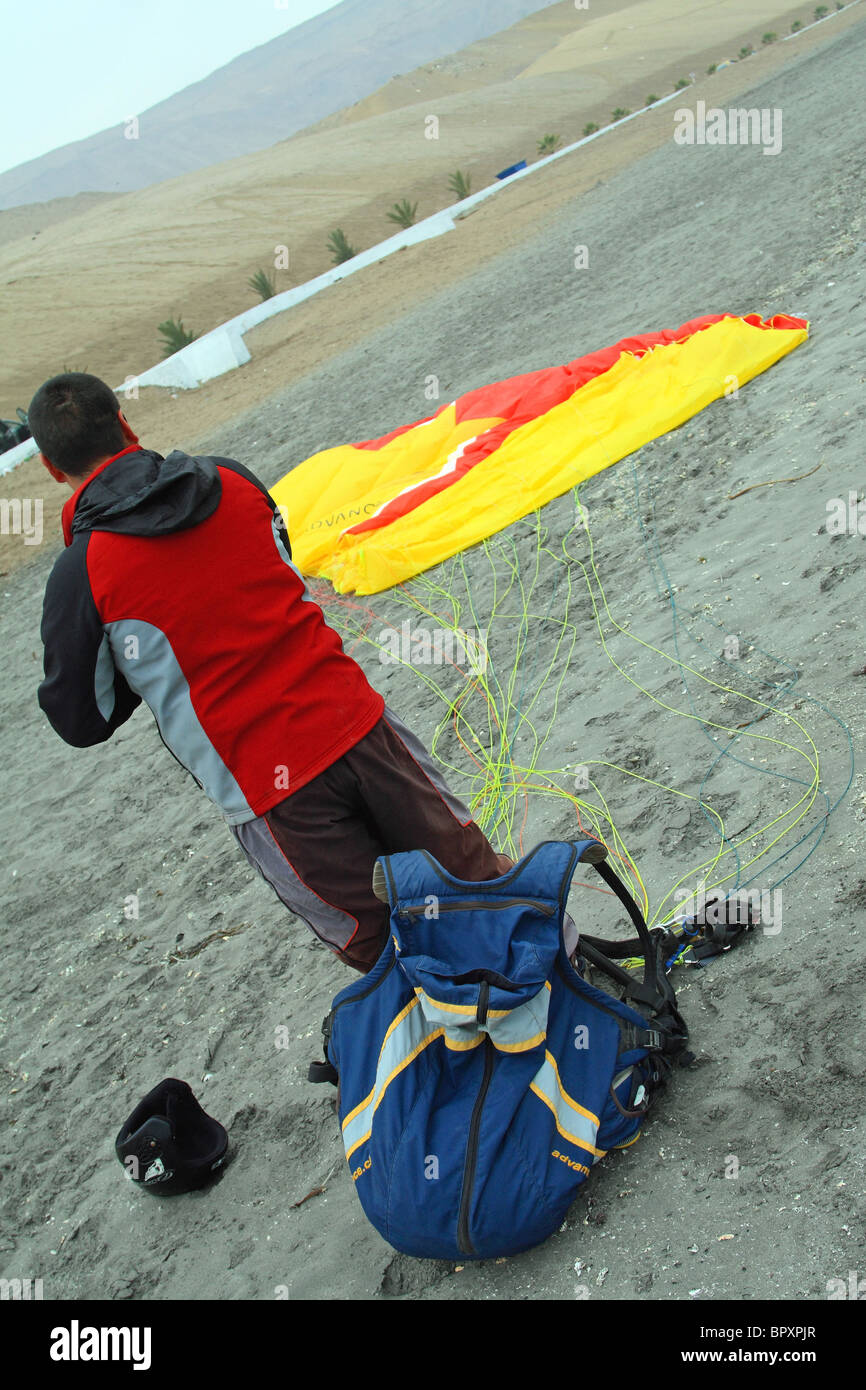 Paraglider folding his canopy, near the city of Iquique, northern Chile ...