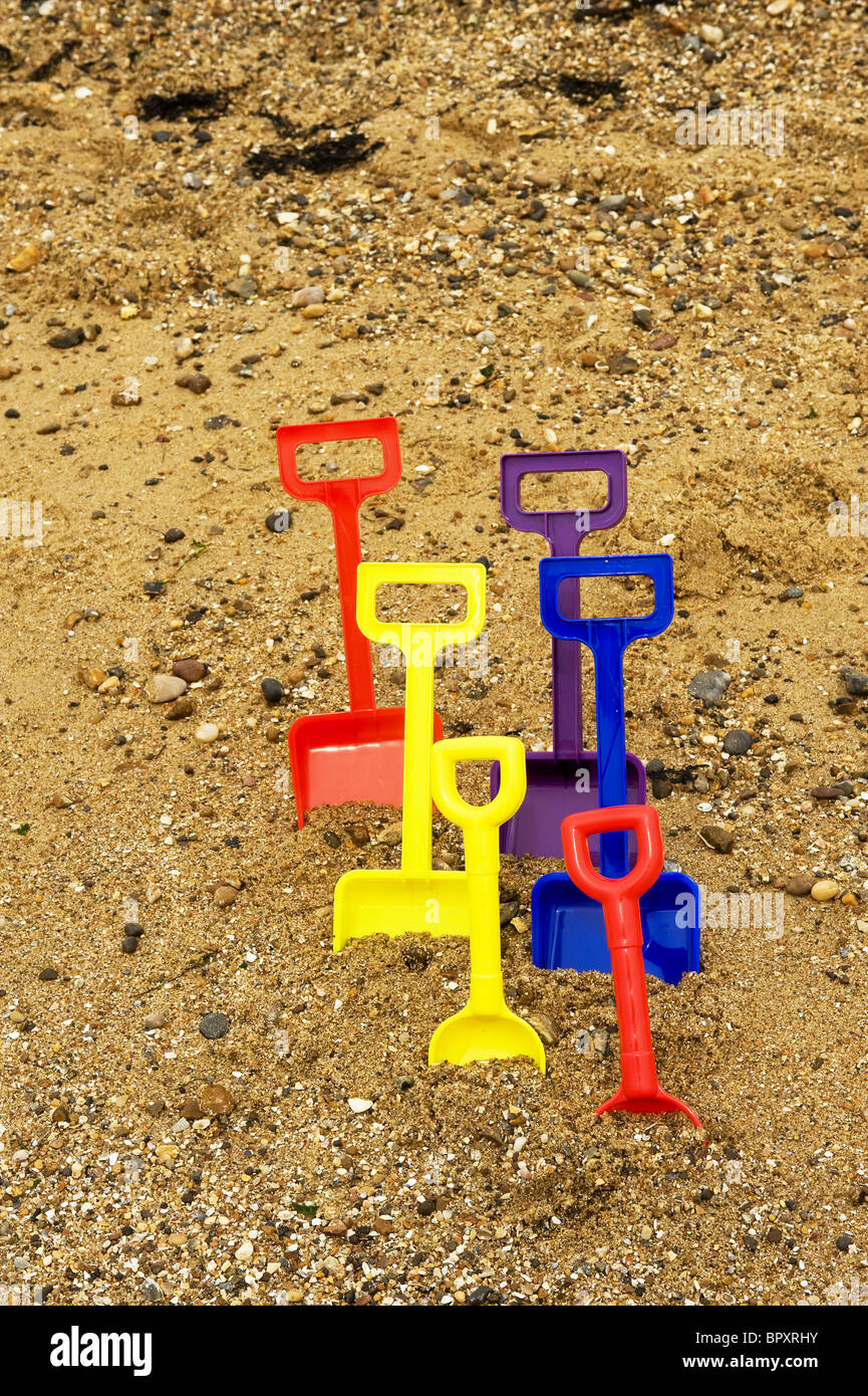 Plastic spades in the sand on a beach Stock Photo - Alamy