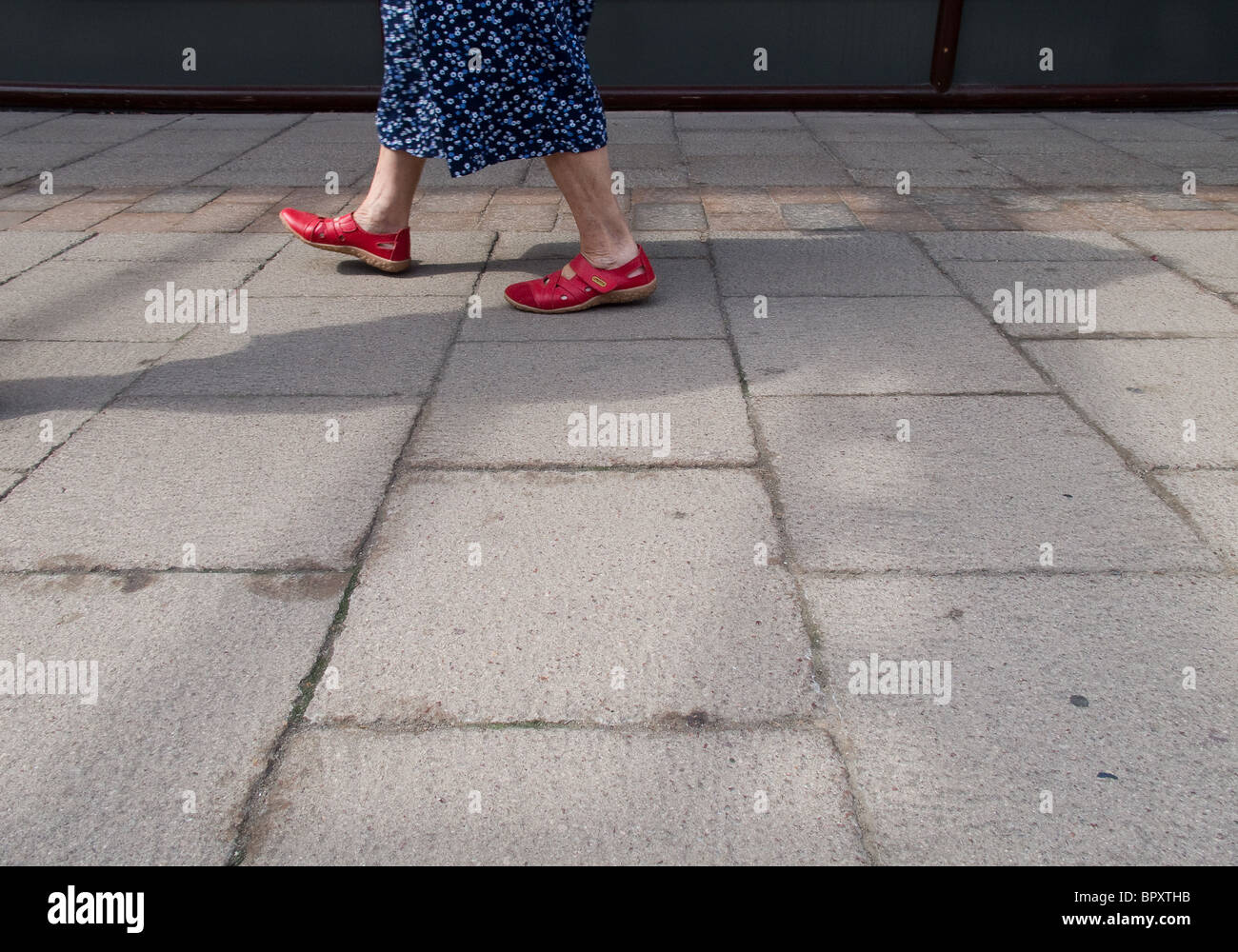 A person walking on a pavement Stock Photo - Alamy