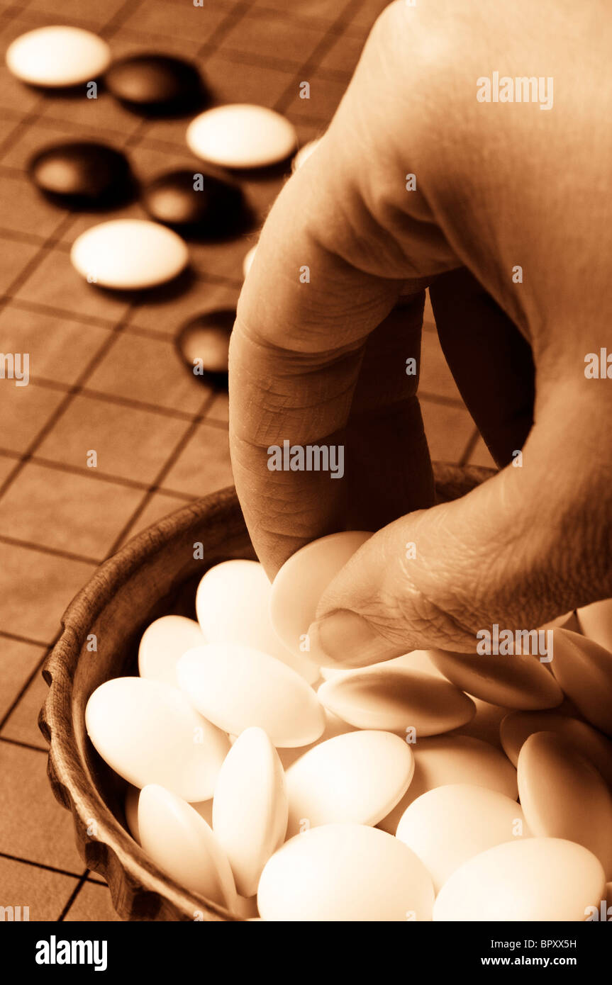 hand of a woman playing a stone in a Go game Stock Photo - Alamy