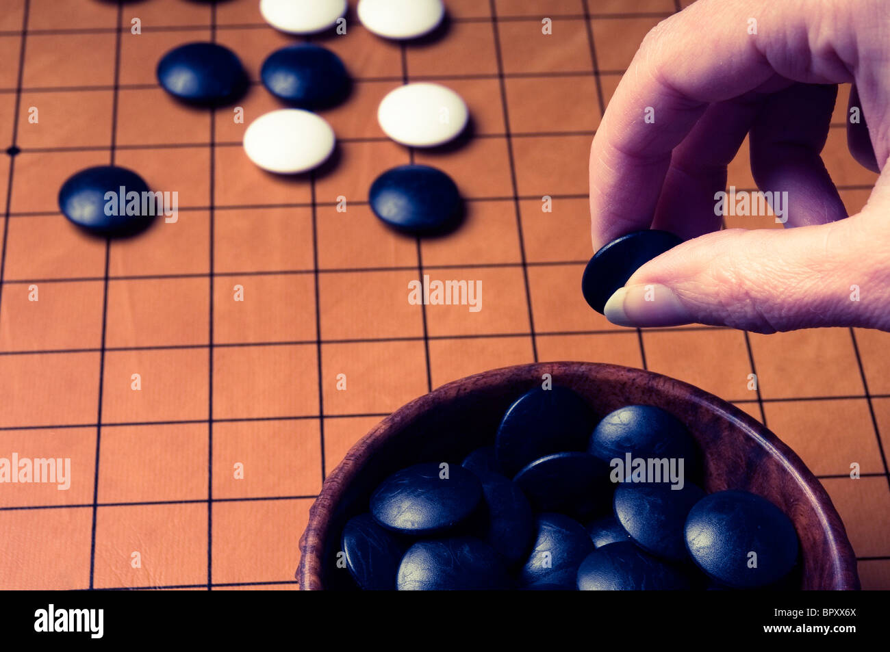 hand of a woman playing a stone in a Go game Stock Photo - Alamy