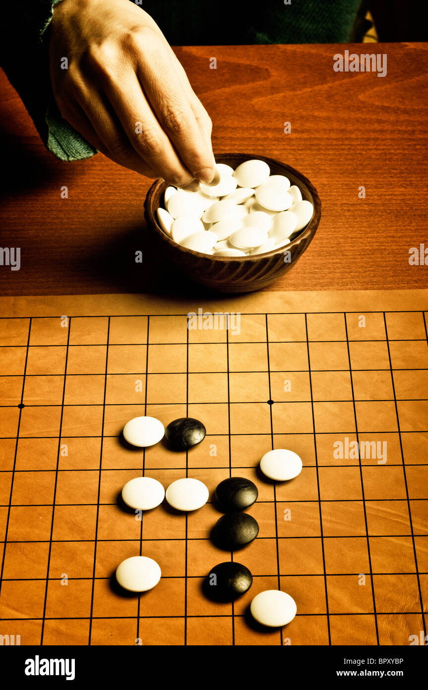 hand of a woman playing a stone in a Go game Stock Photo - Alamy