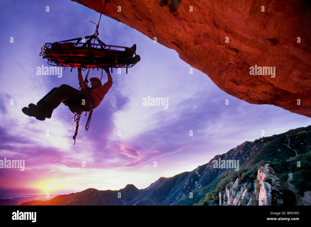 Search and Rescue climber hanging from litter, at sunset, Santa Barbara ...