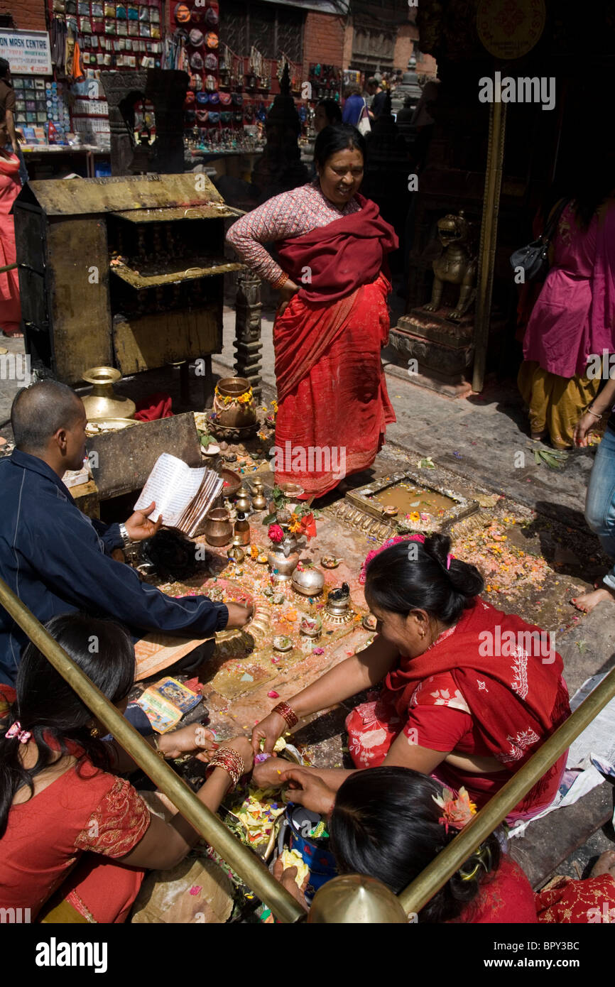 Hindu worshipers making food offerings to a shrine within Swayambhunath ...