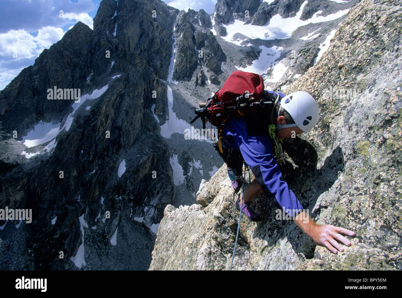 A man climbs a granite cliff high on Disappointment Peak, Grand Teton ...