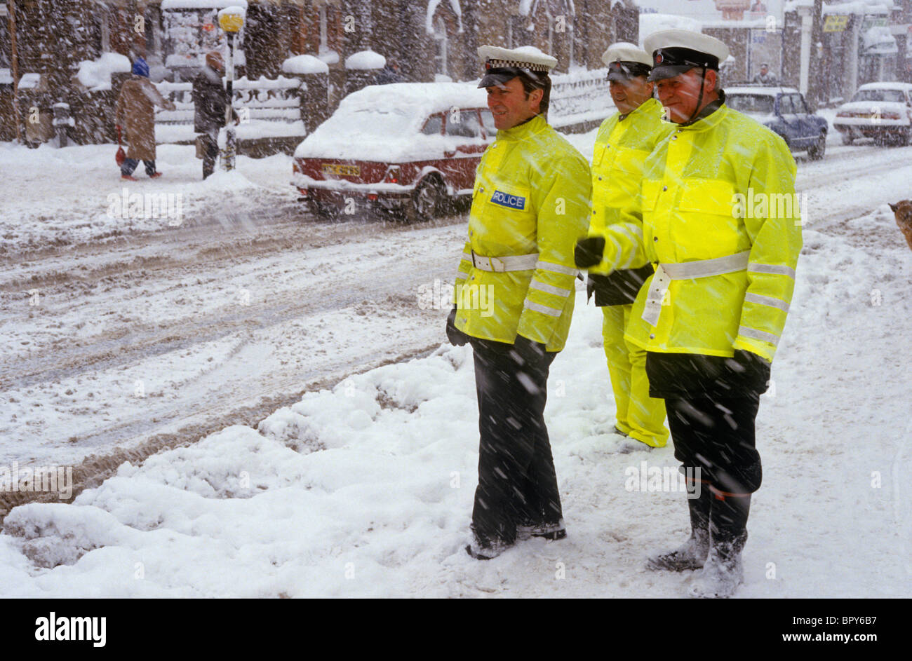 Three police officers are watching on-coming traffic as it negotiates ...
