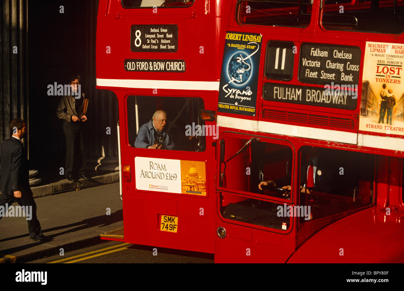In the bustle of a modern metropolis, two red Routemaster buses pass ...