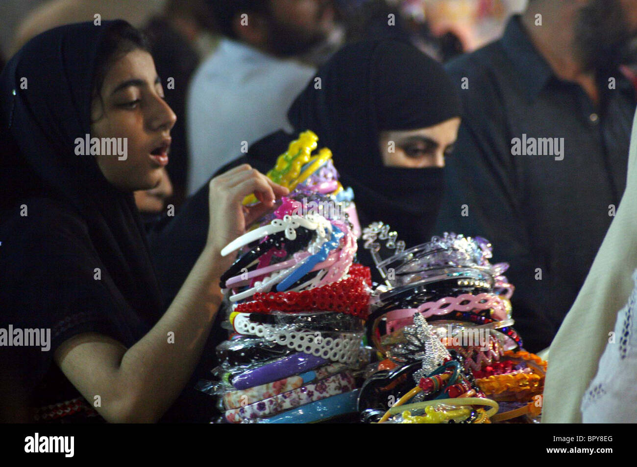 Girl selects hair band for her Eid preparation at a stall at Saddar ...