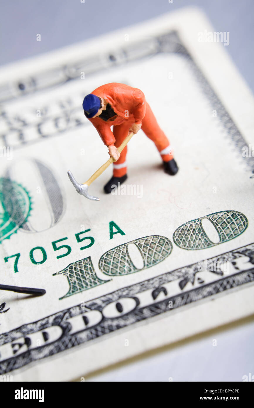Worker figurines placed on a 100 dollar bill Stock Photo - Alamy