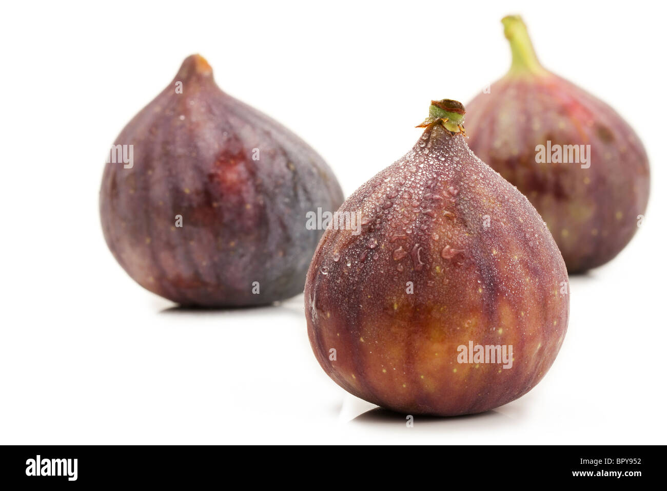 wet fig in front of two figs on white background Stock Photo - Alamy