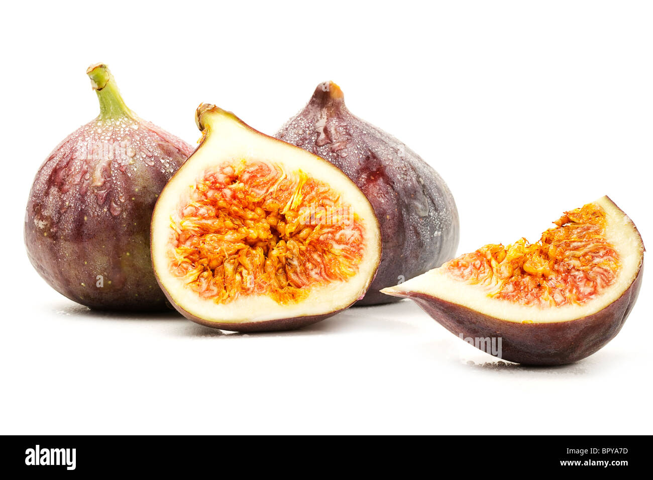 two wet figs and a half and a fig wedge on white background Stock Photo ...