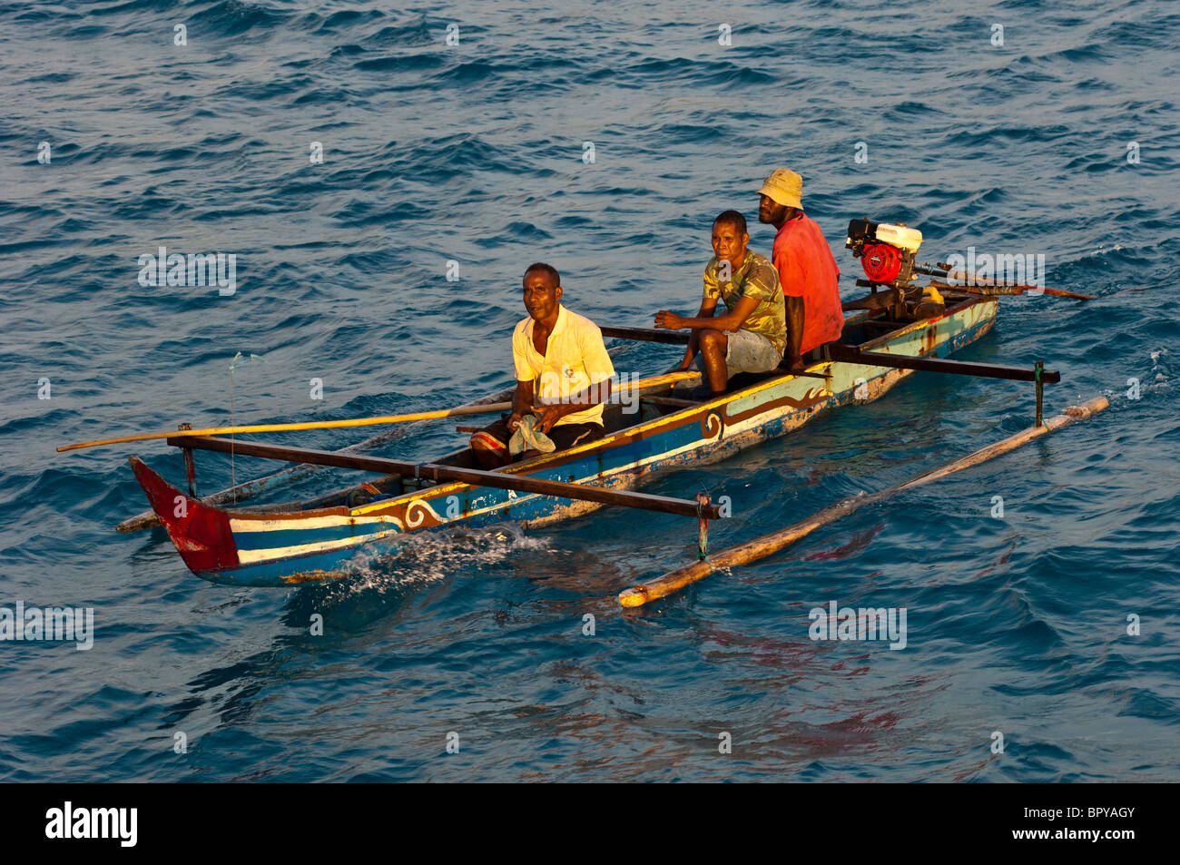 Fishermen in a traditional outrigger canoe, Mapia Atoll, West Papua ...