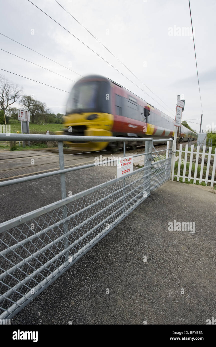 Train going through a pedestrian level crossing Stock Photo - Alamy