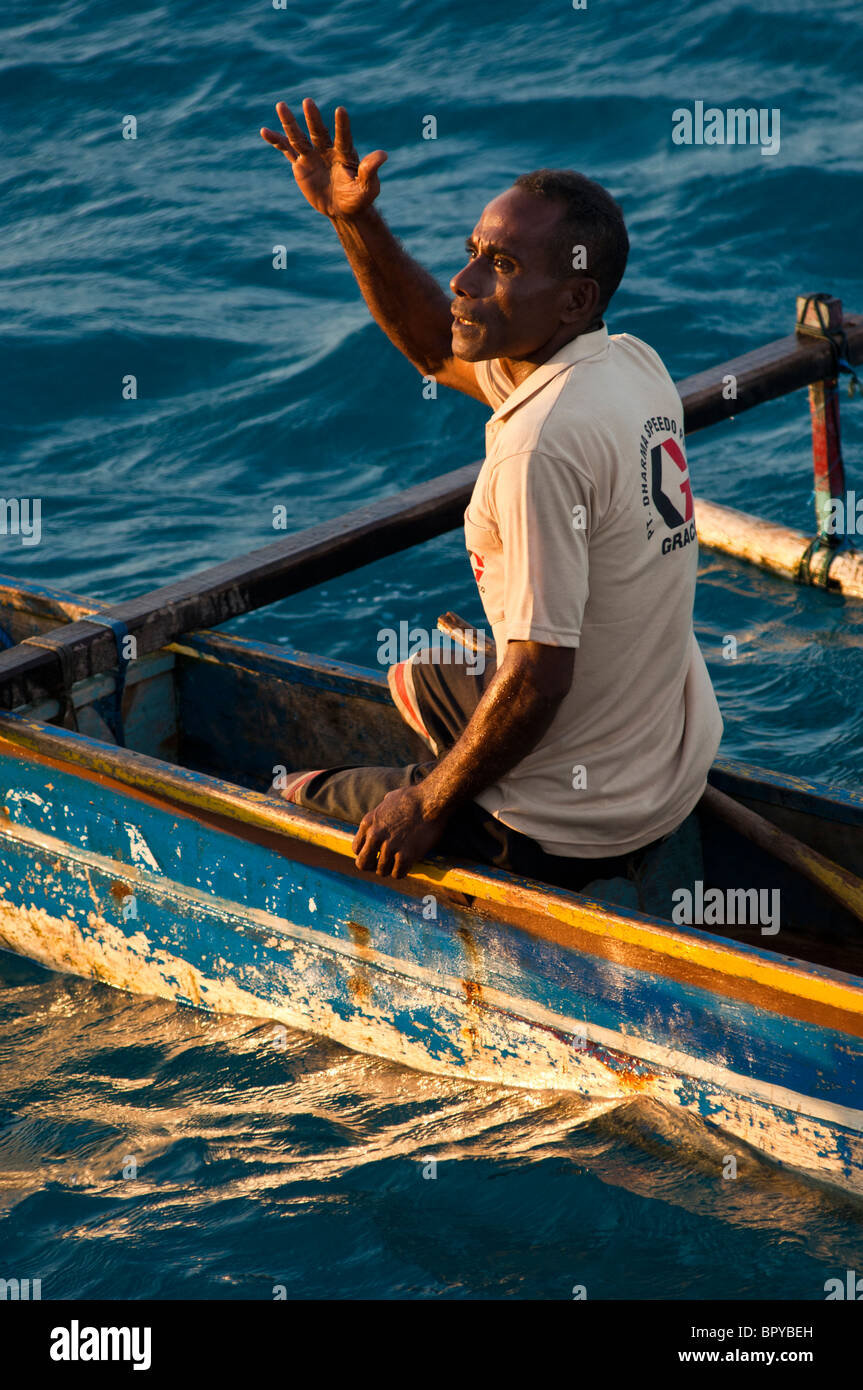 Fishermen in a traditional outrigger canoe, Mapia Atoll, West Papua ...