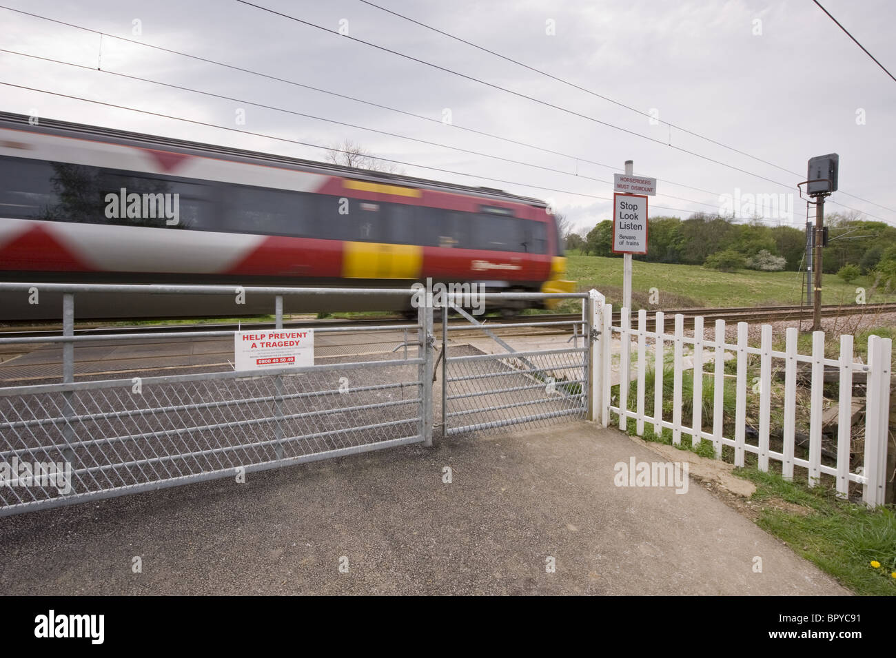 Train going through a pedestrian level crossing Stock Photo - Alamy