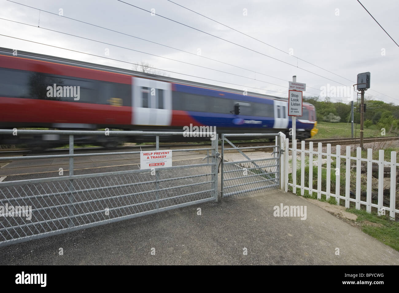 Train going through a pedestrian level crossing Stock Photo - Alamy