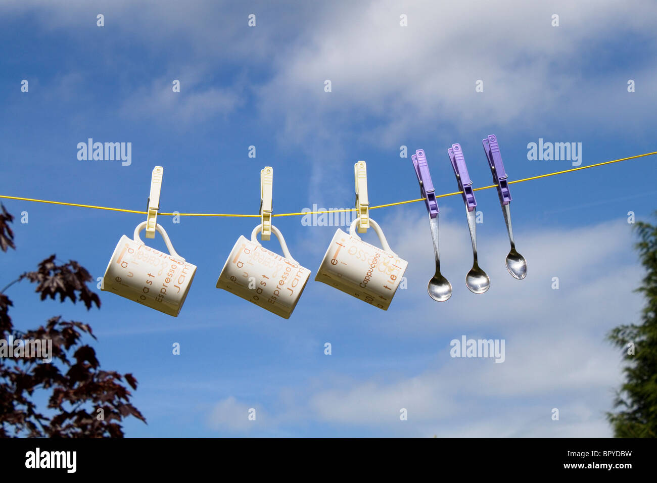 Three mugs and three spoons hanging on washing line to dry Stock Photo ...