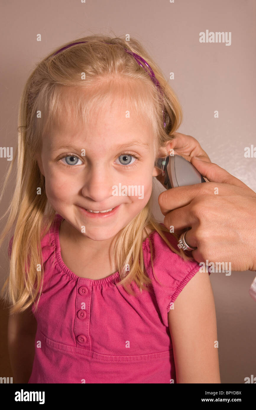 child having a checkup in doctor office, electronic thermometer in her ...