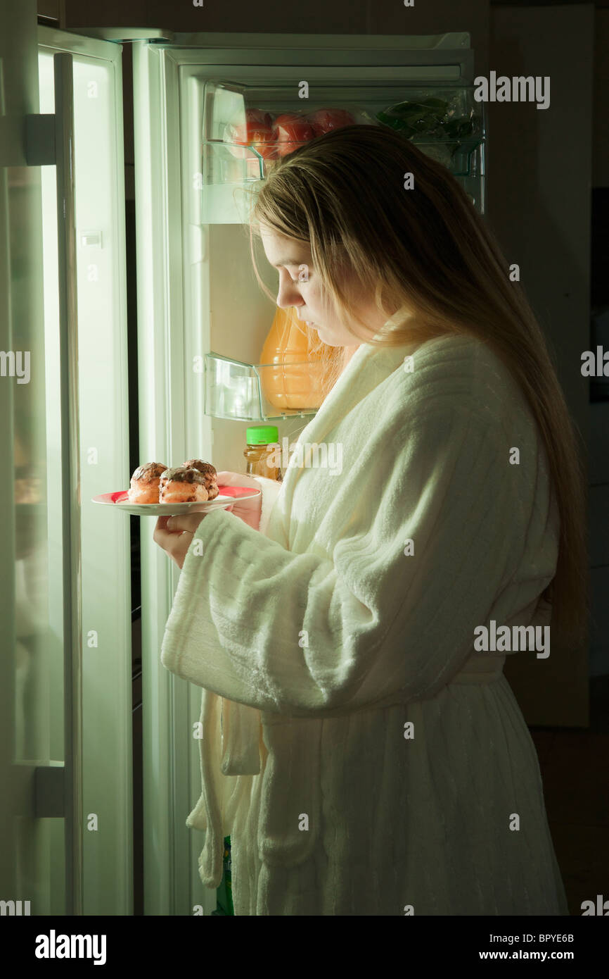 young woman getting food out of fridge for a late night snack Stock ...