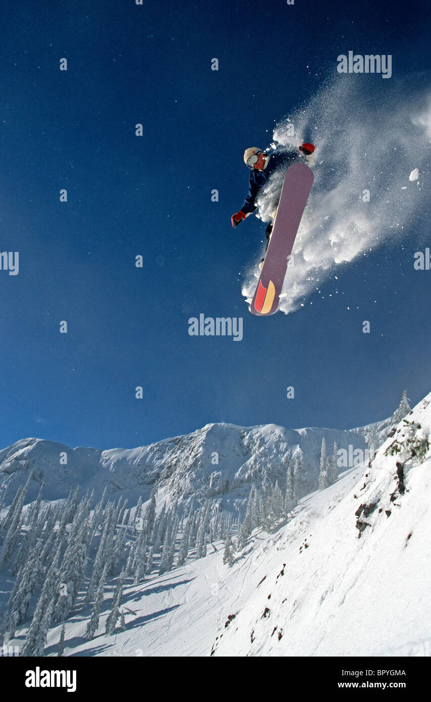 Young male adult jumping cliff on snowboard at Fernie Alpine Resort, BC ...