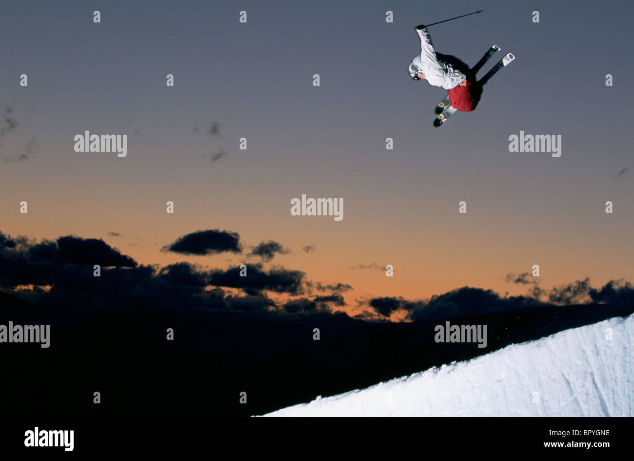 Skier jumps in half pipe at sunset Stock Photo - Alamy