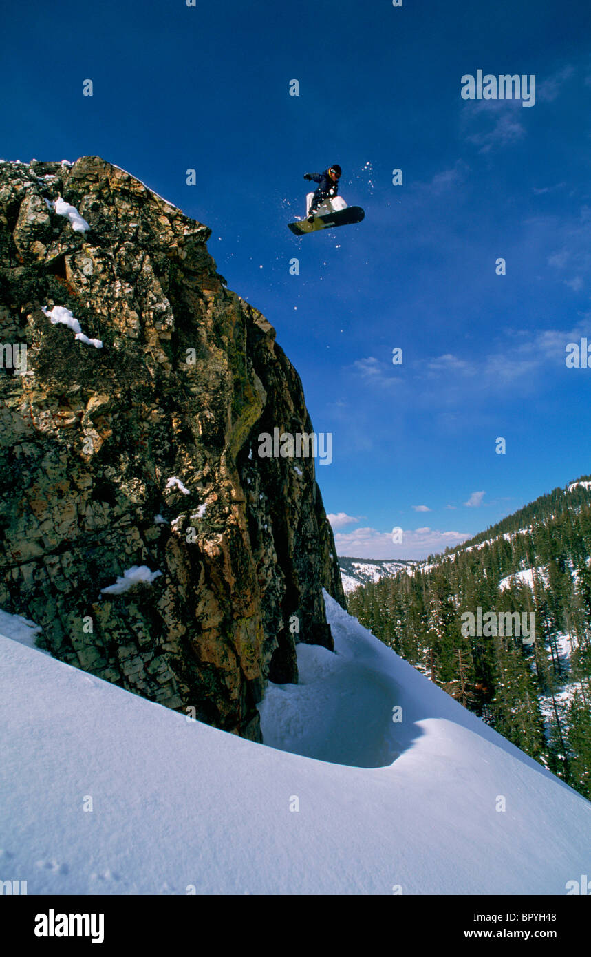 Big cliff launch by snowboarder Stock Photo - Alamy
