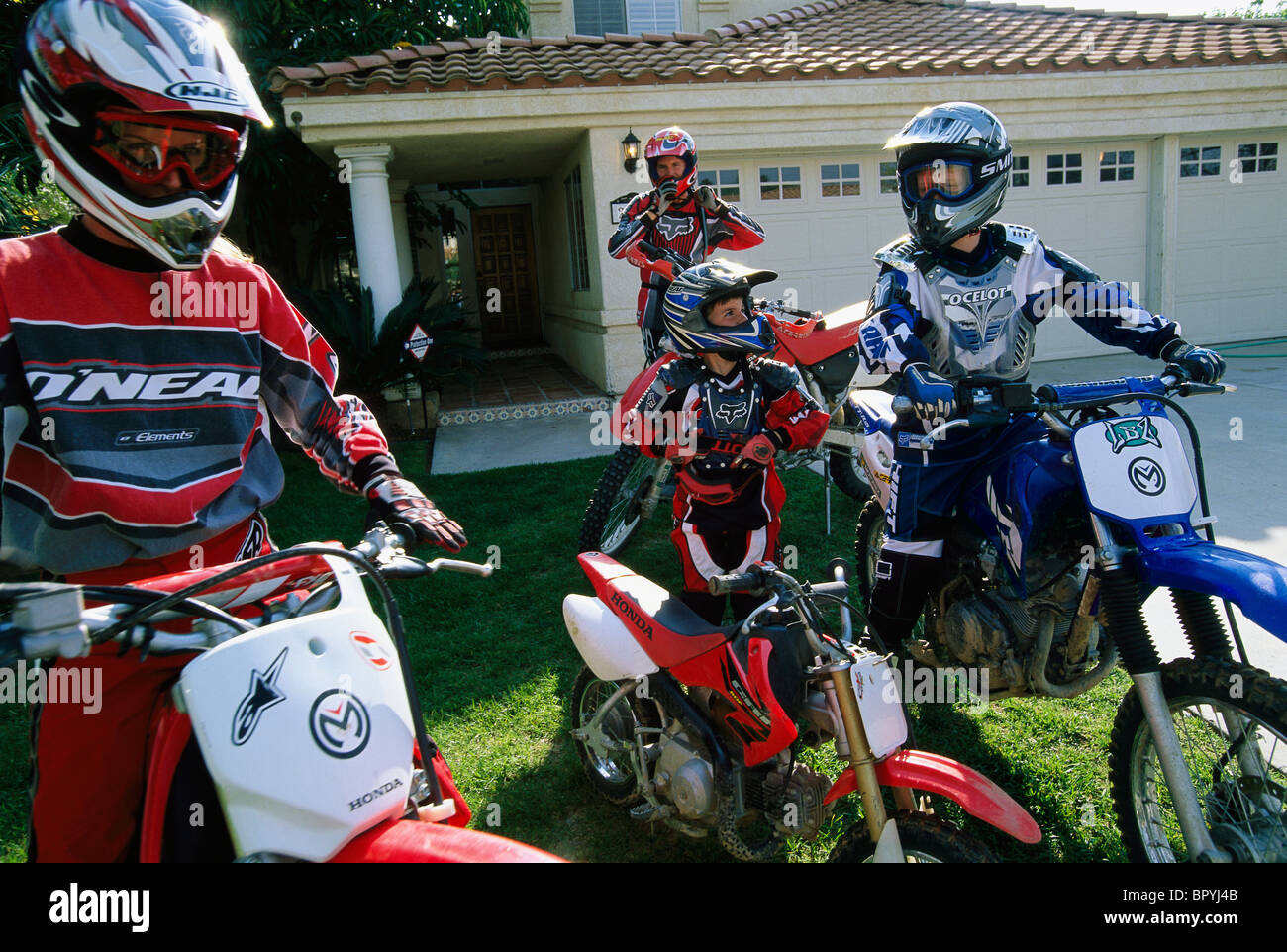 A family gets ready to go for a family dirtbike ride Stock Photo - Alamy