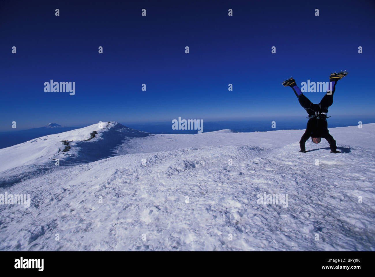 Man doing handstand in the snow on the summit of a mountain Stock Photo ...