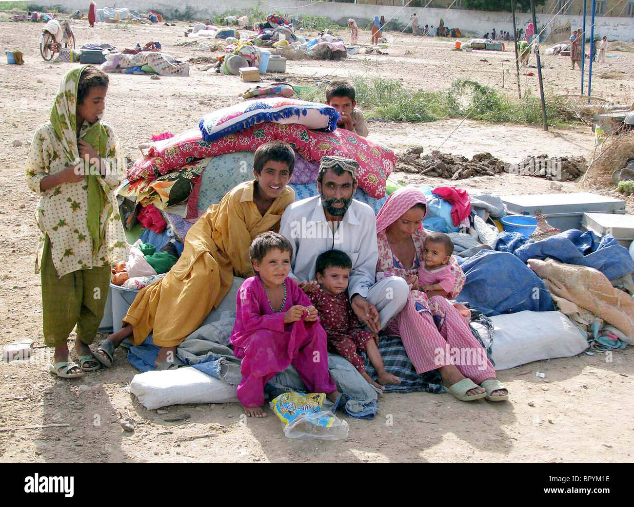 Flood affected people sit with their household under the open sky due ...