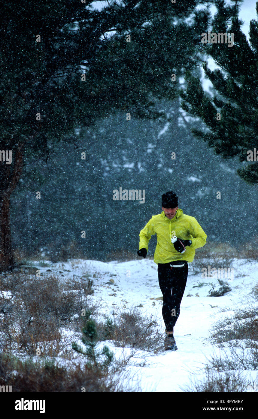 Man running in snow storm Stock Photo - Alamy