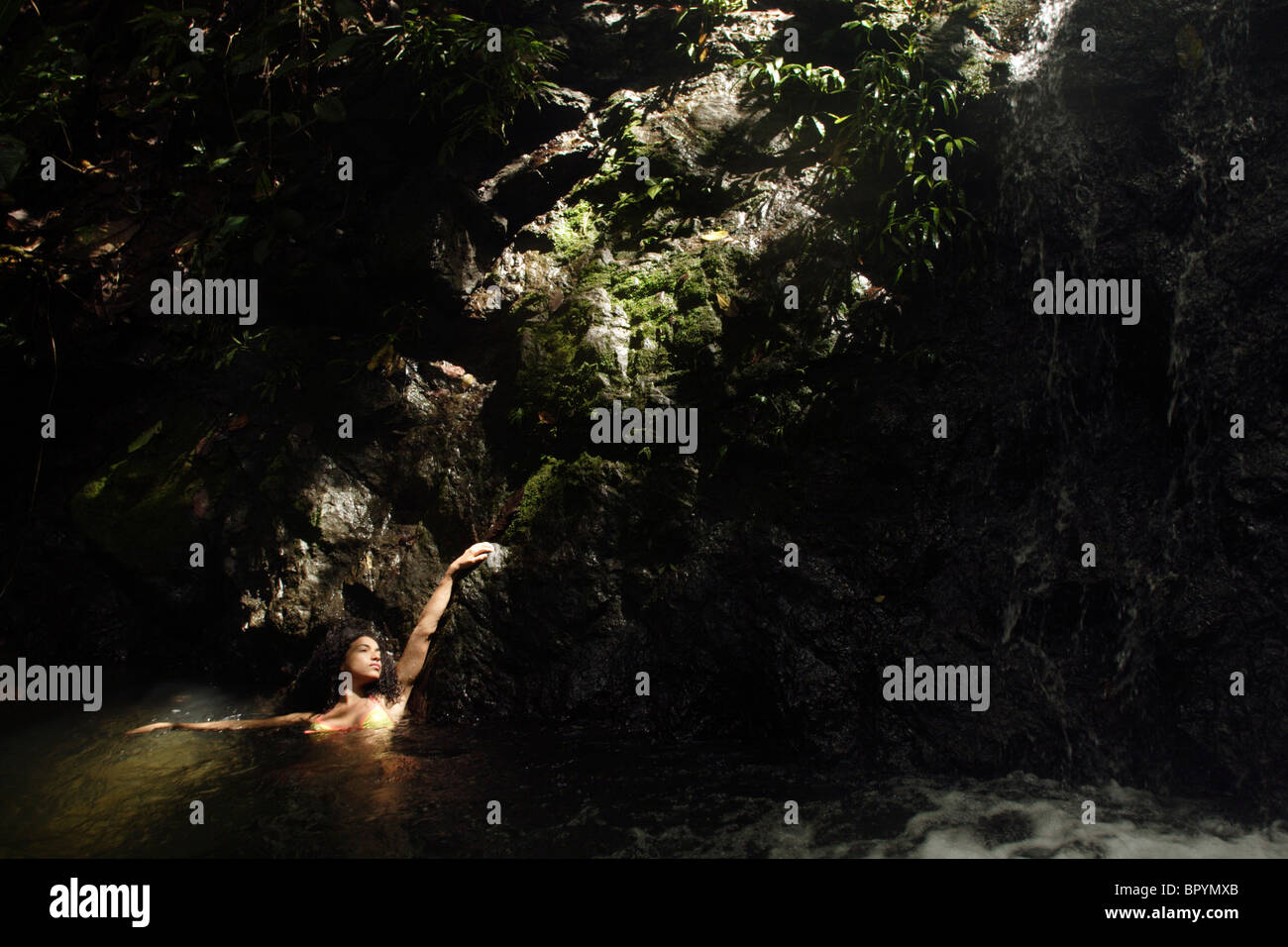 A woman relaxes in a rainforest pool near Nuqui, Colombia Stock Photo ...