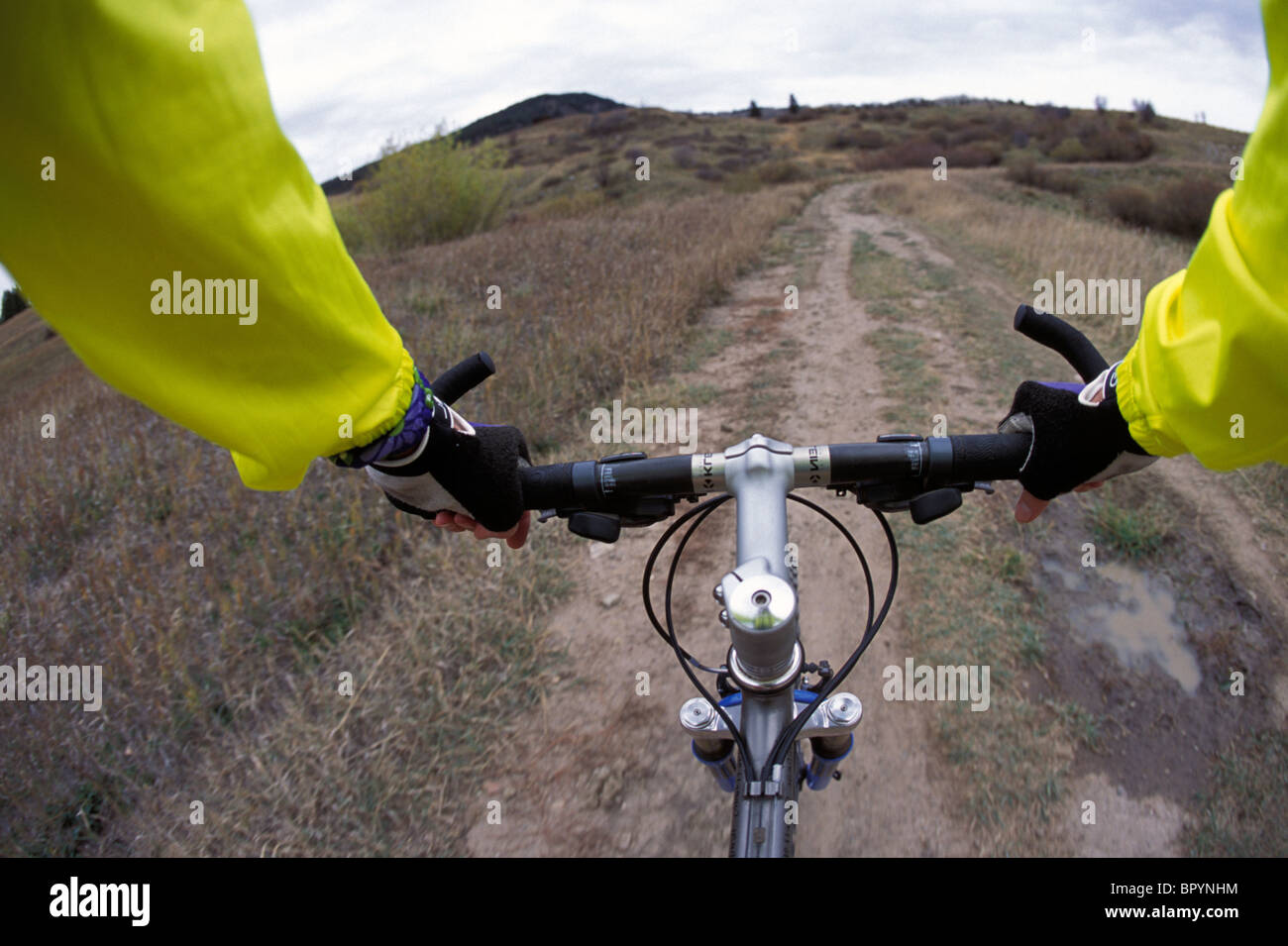 The view over a woman's handle bars as she rides her mountain bike on a ...