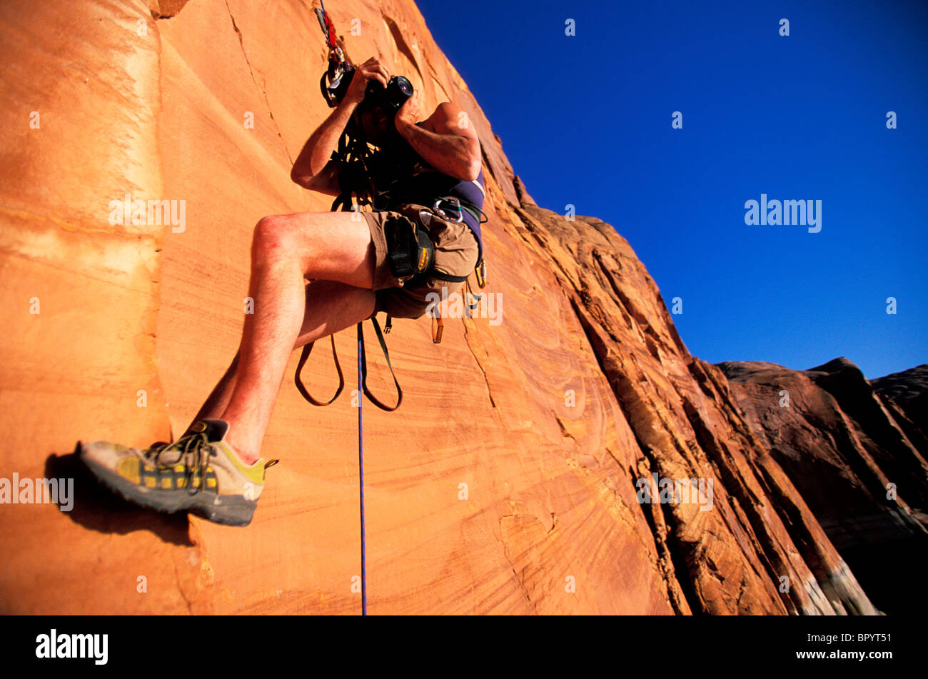 A man with a camera, climbing Stock Photo - Alamy