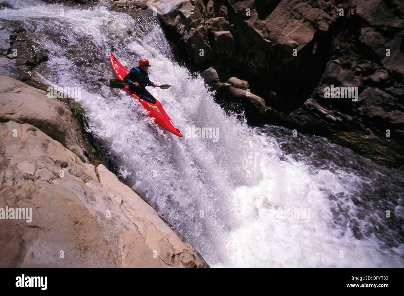 A man goes over a waterfall in a kayak Stock Photo - Alamy