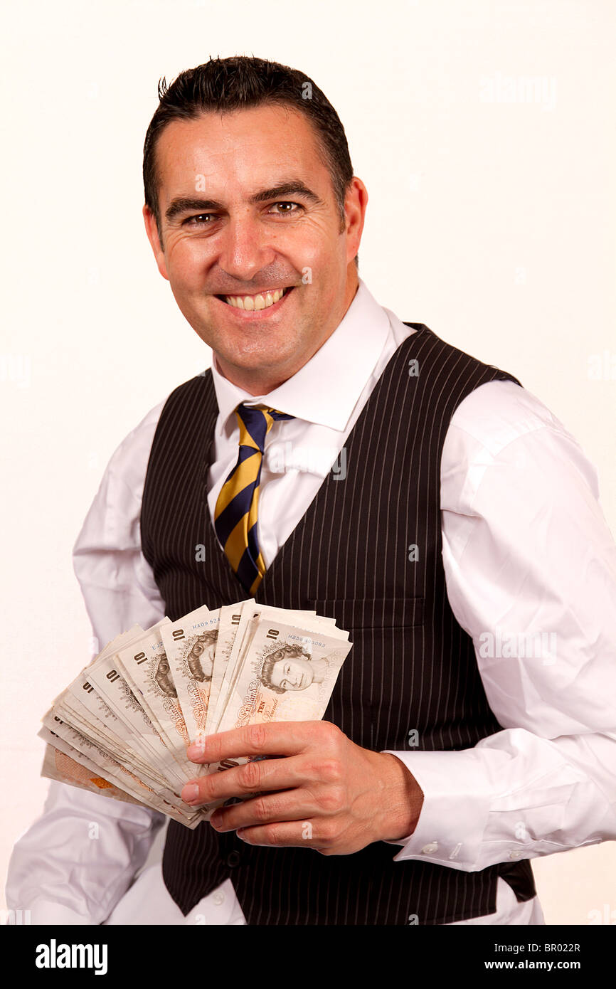 Smiling businessman holding a 'fan' of ten pound notes Stock Photo - Alamy