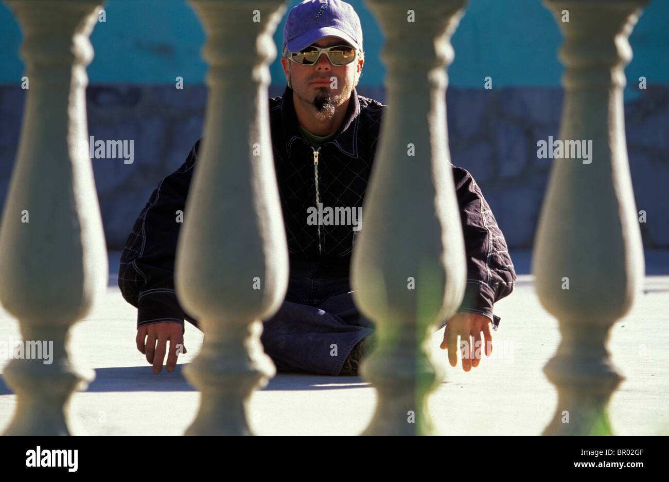 A man sitting behind a fence Stock Photo - Alamy