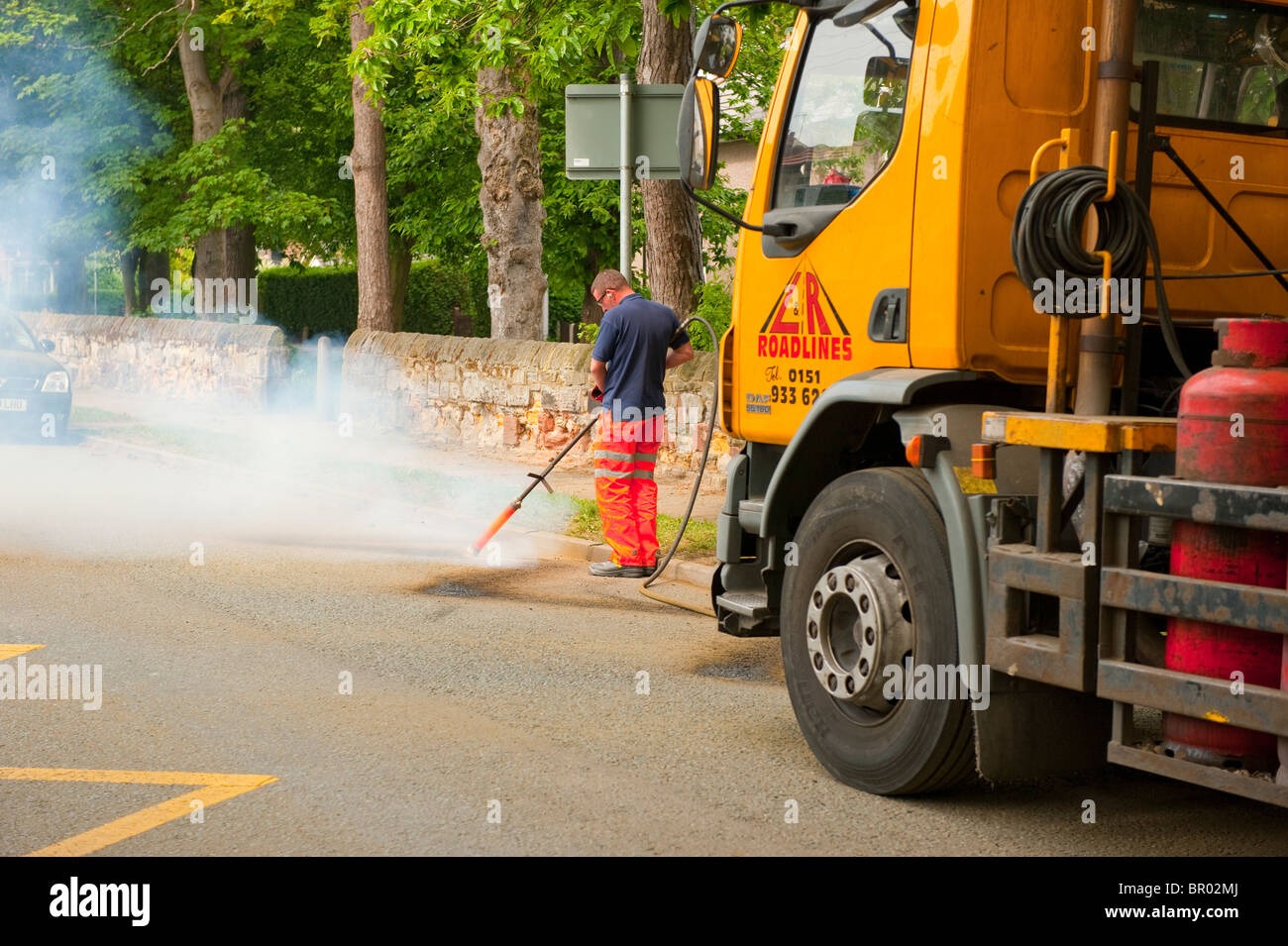 Road marking yellow lines being removed by burning off Stock Photo - Alamy