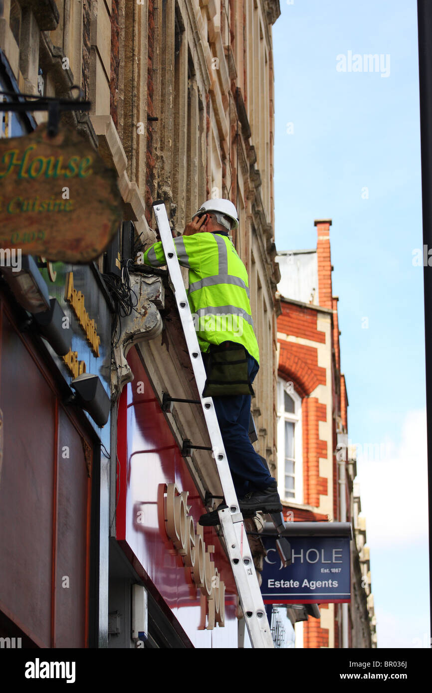 Workman on ladder using mobile phone Stock Photo - Alamy Workman on ladder using mobile phone Stock Photo - Alamy
