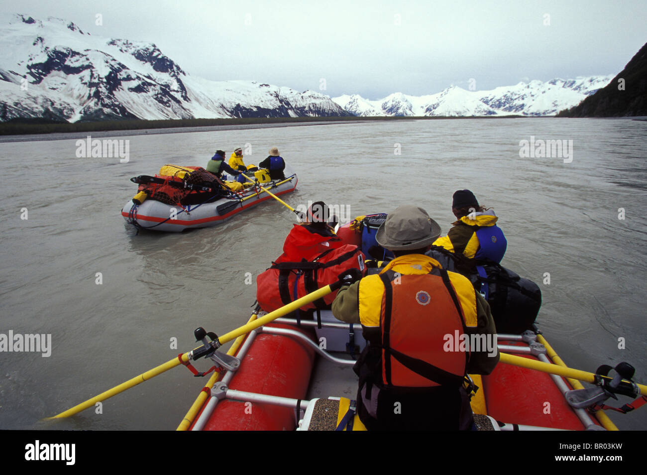 Young adults rafting on Alsek River near Walker Glacier during ski ...