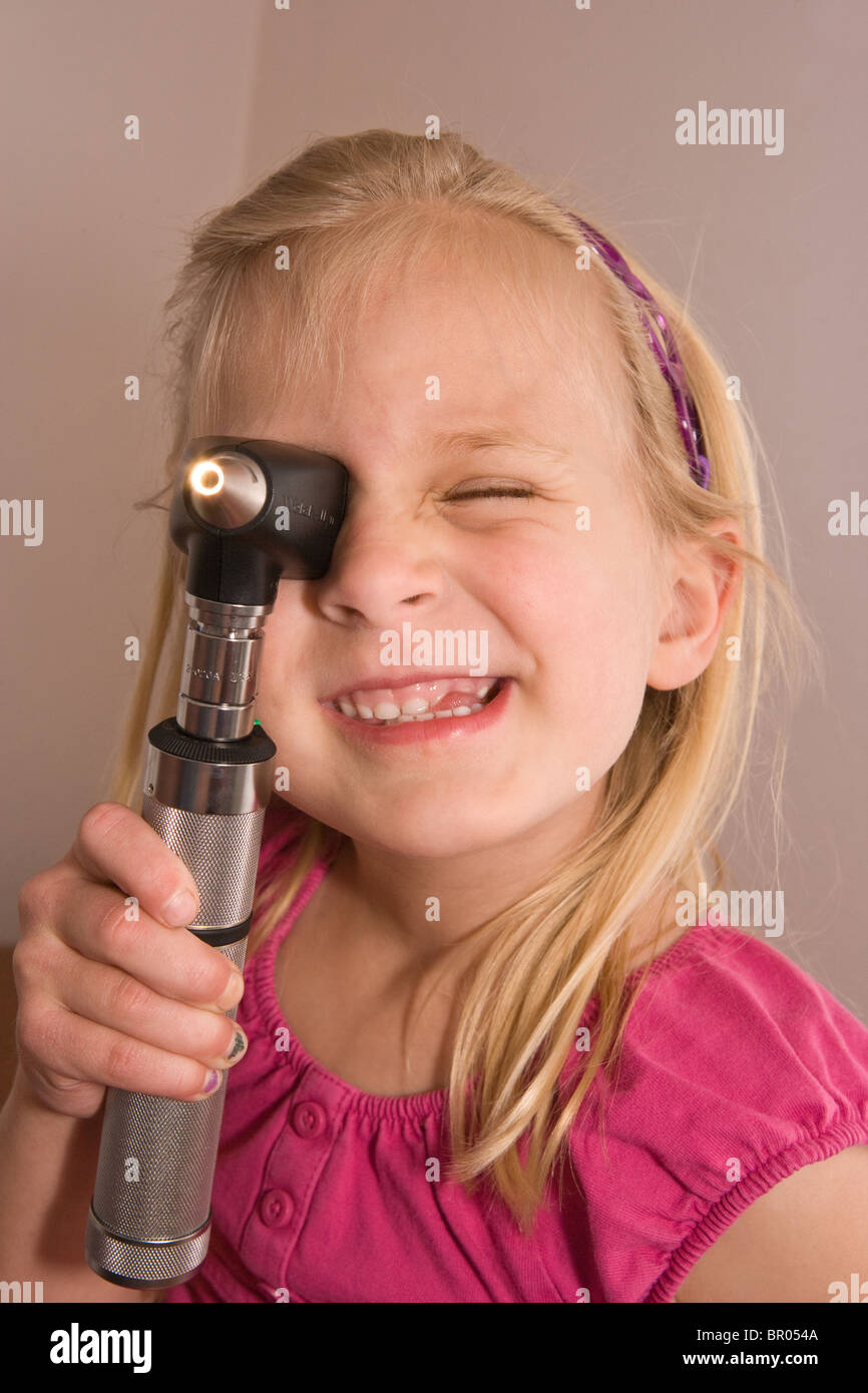 young girl holding an otoscope and learning about the inner ear in a ...