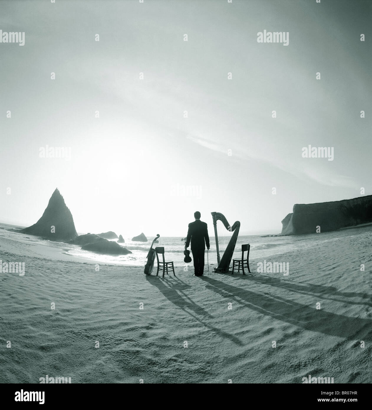 Man on the beach with classical music instruments Stock Photo - Alamy