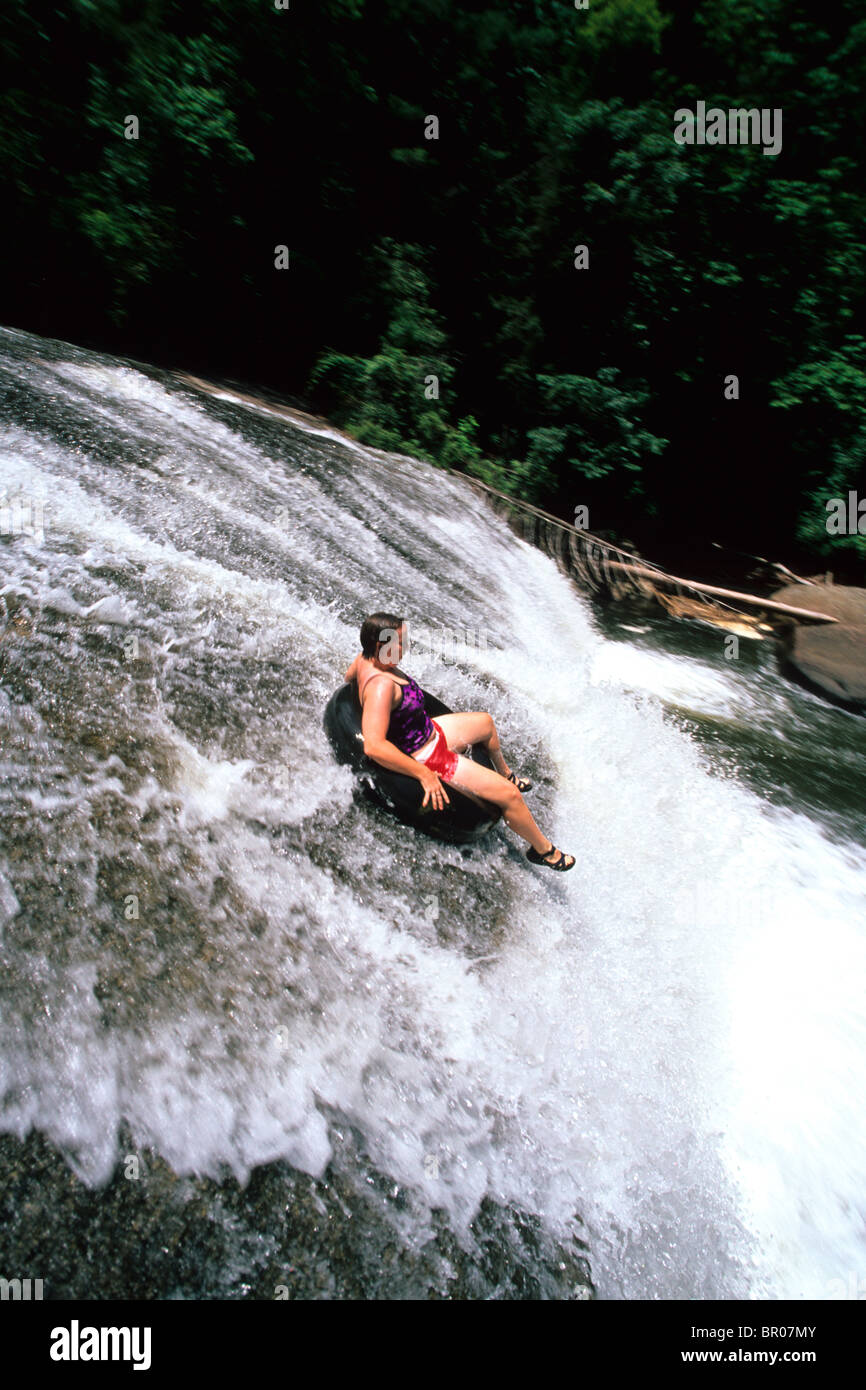 A woman rides an innertube over a waterfall Stock Photo - Alamy